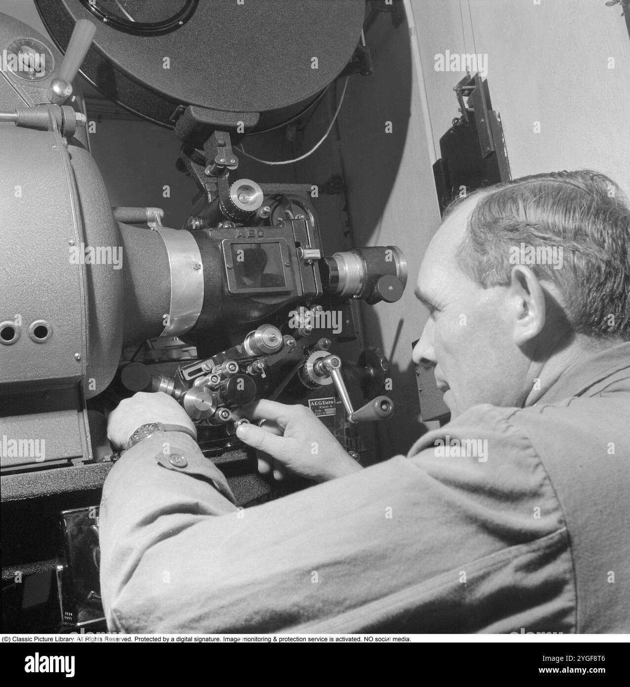 Behind the scenes at the cinema. The man operating the projector at the ...