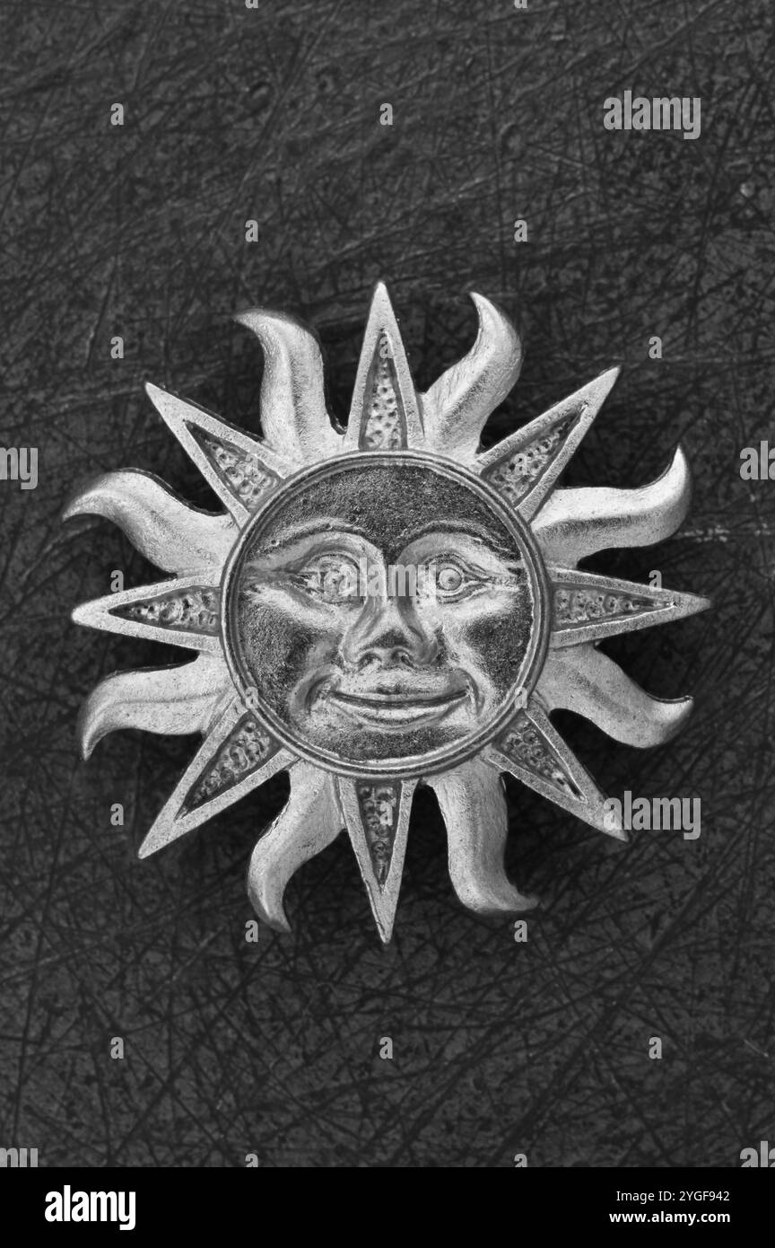 Monochrome image of model of sun with big face and flickering rays ...