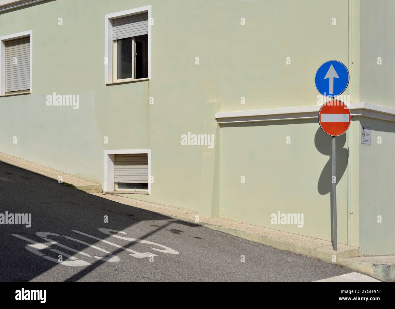 traffic signs and painted word stop on a downhill road, Santa Teresa di ...