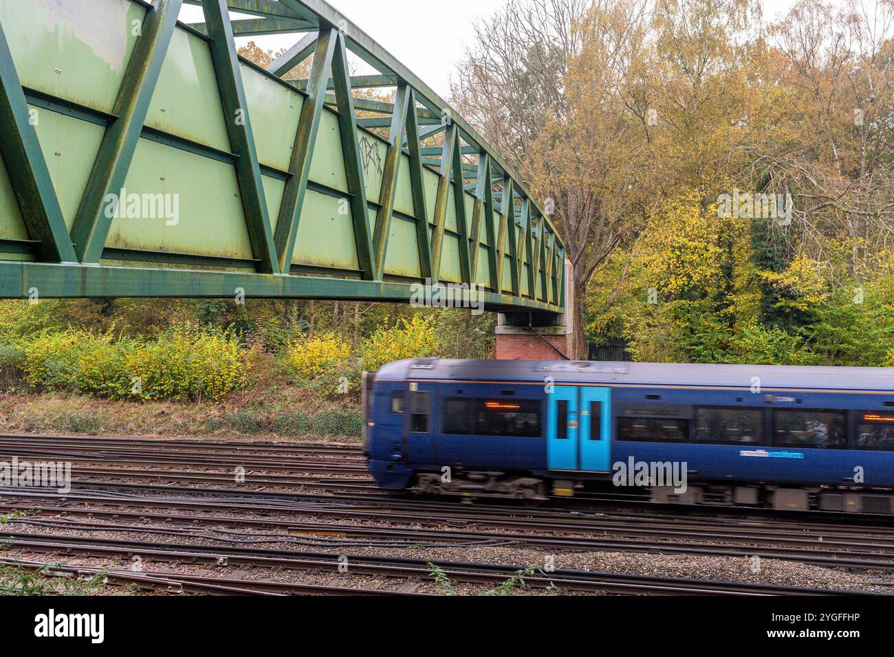 South Eastern railway train passing under a railway footbridge Stock ...