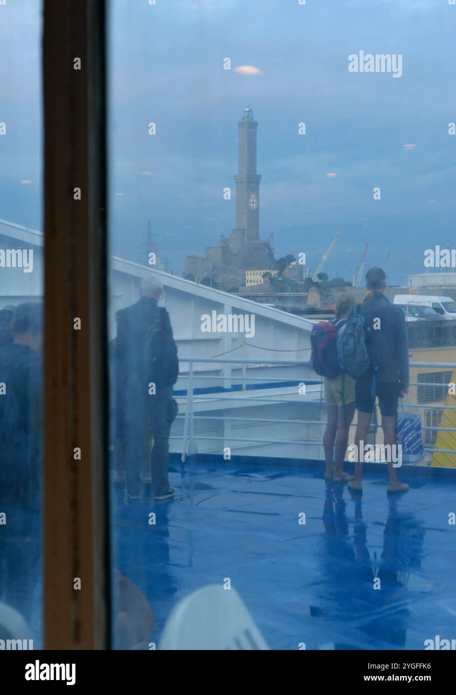 view through ferry ship window of the exterior deck with passengers and ...