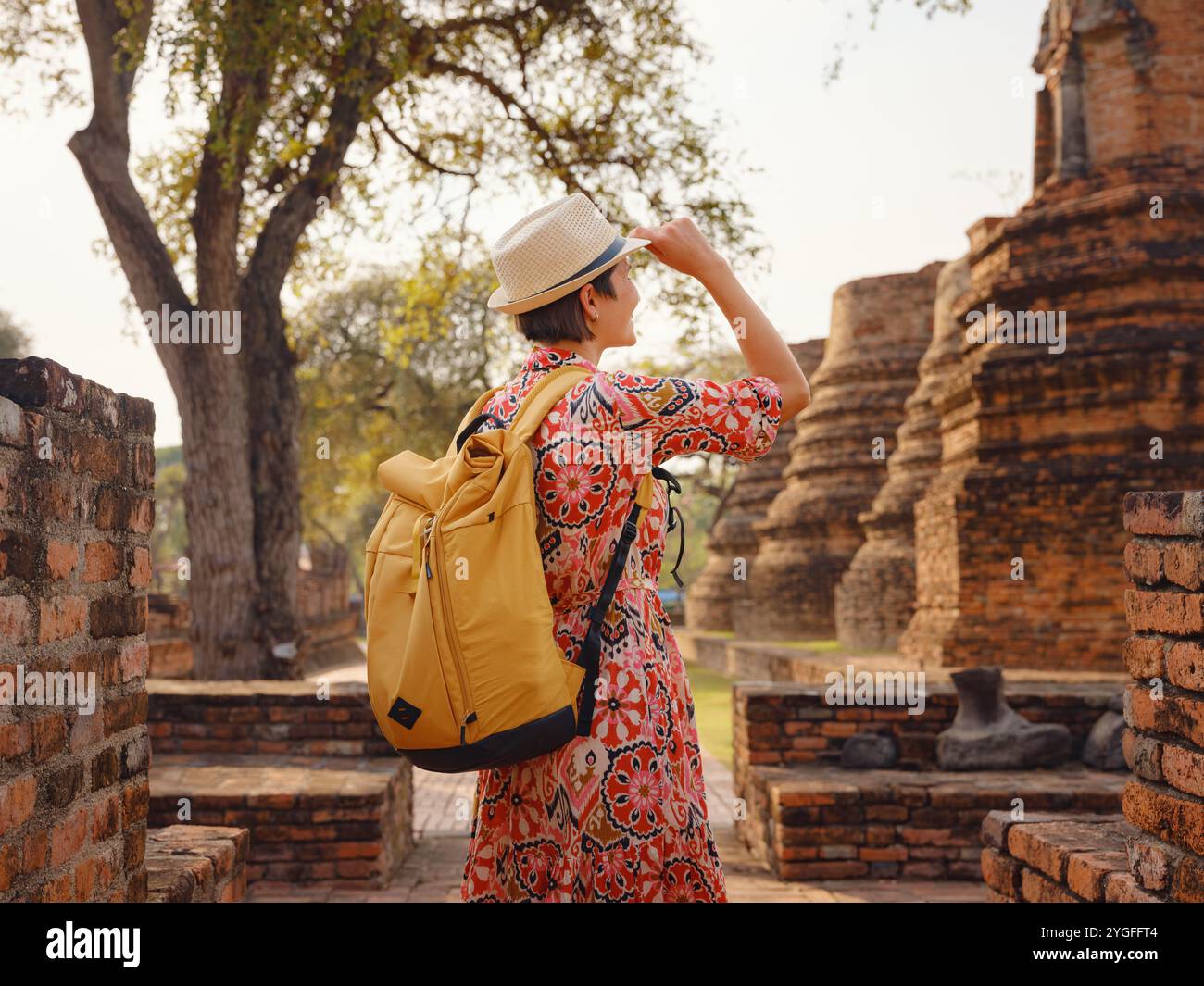 Young female tourist in dress exploring historic park of Ayutthaya ...