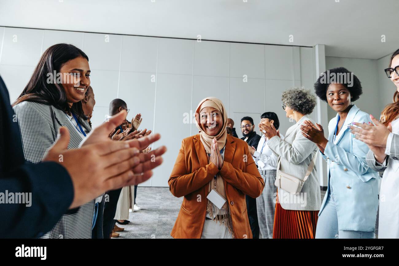 Diverse group of professionals clapping and celebrating together in a ...