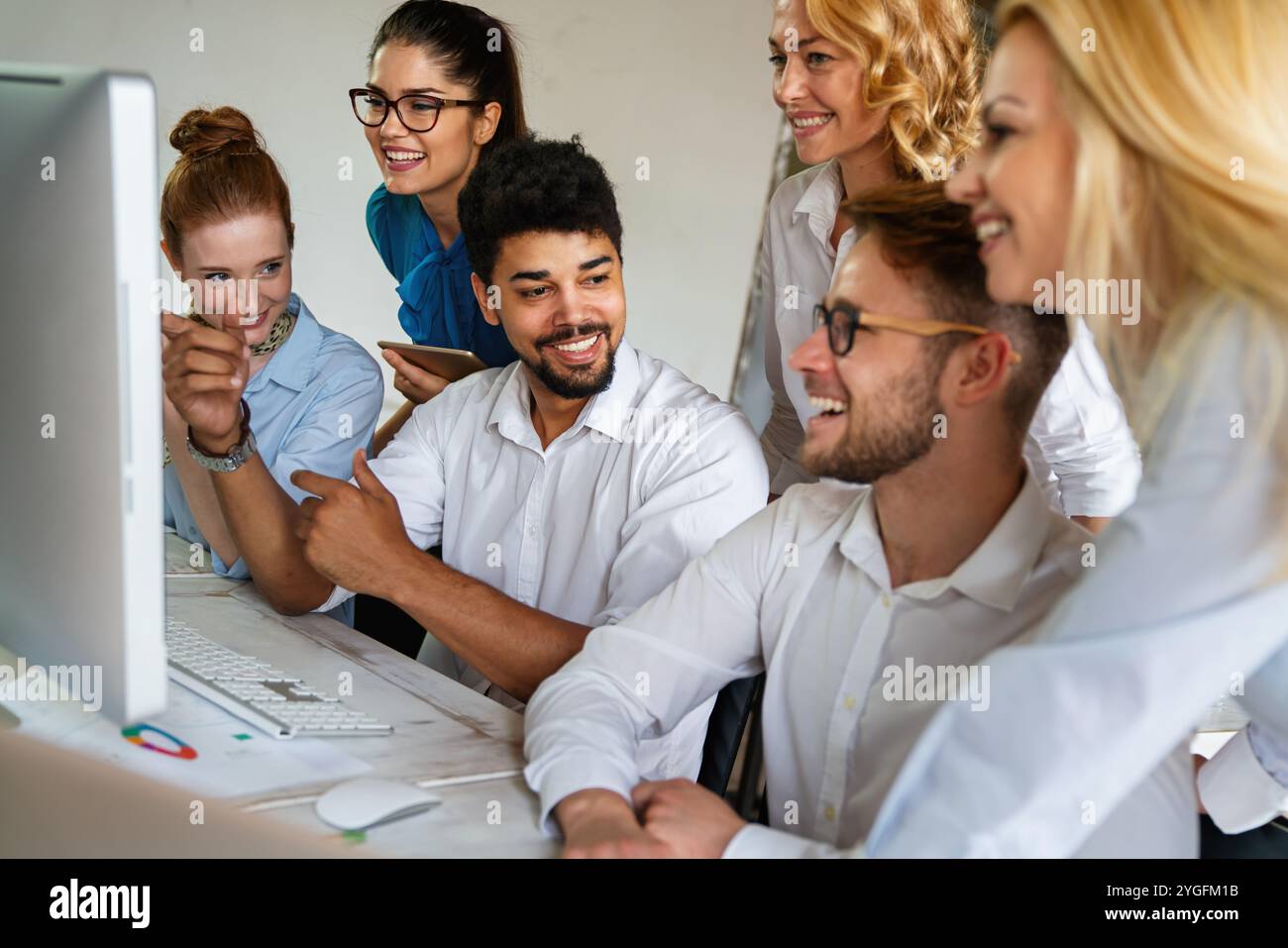 Smiling group of diverse businesspeople working together around a ...