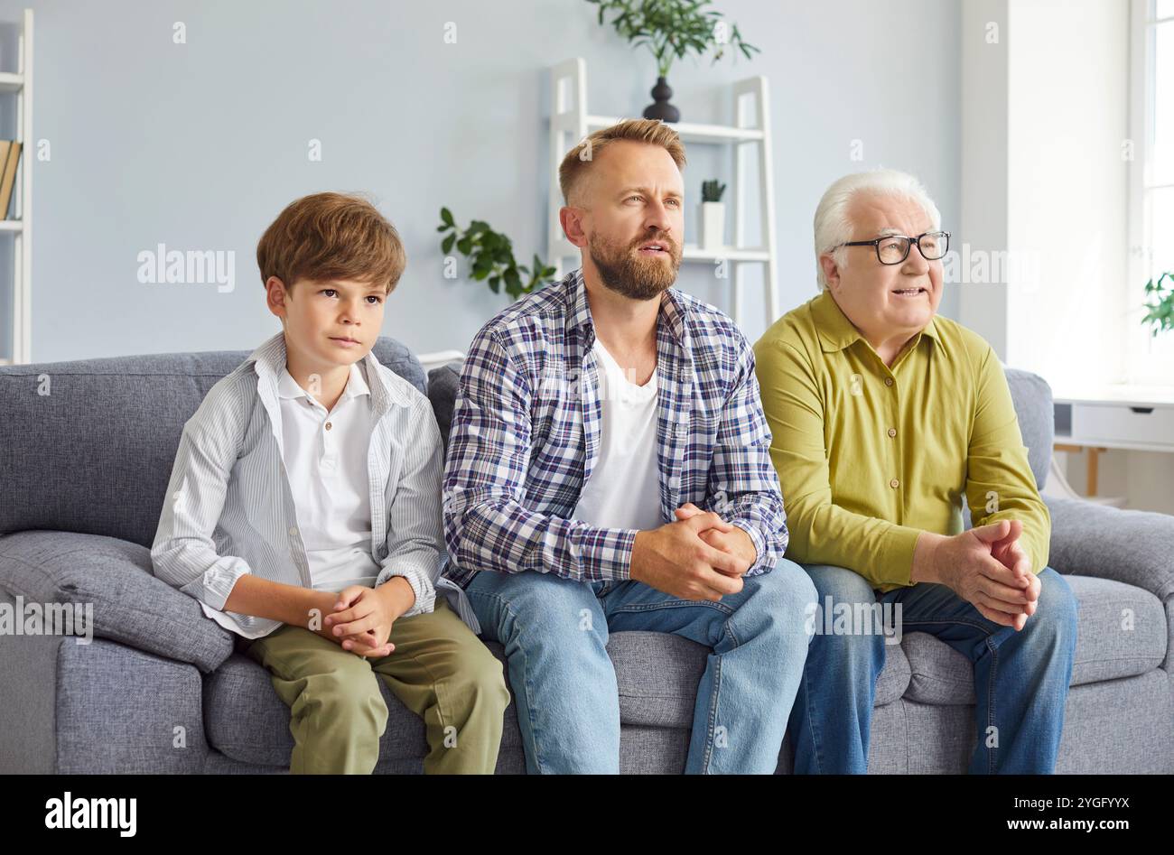Senior grandfather, father and child boy sitting on sofa at home ...