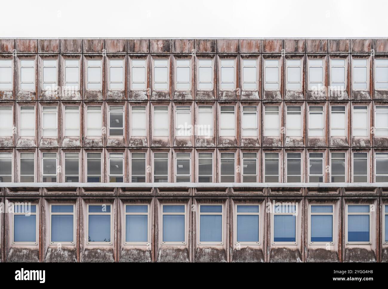 Symmetrical urban facade of a brutalist building with square windows ...