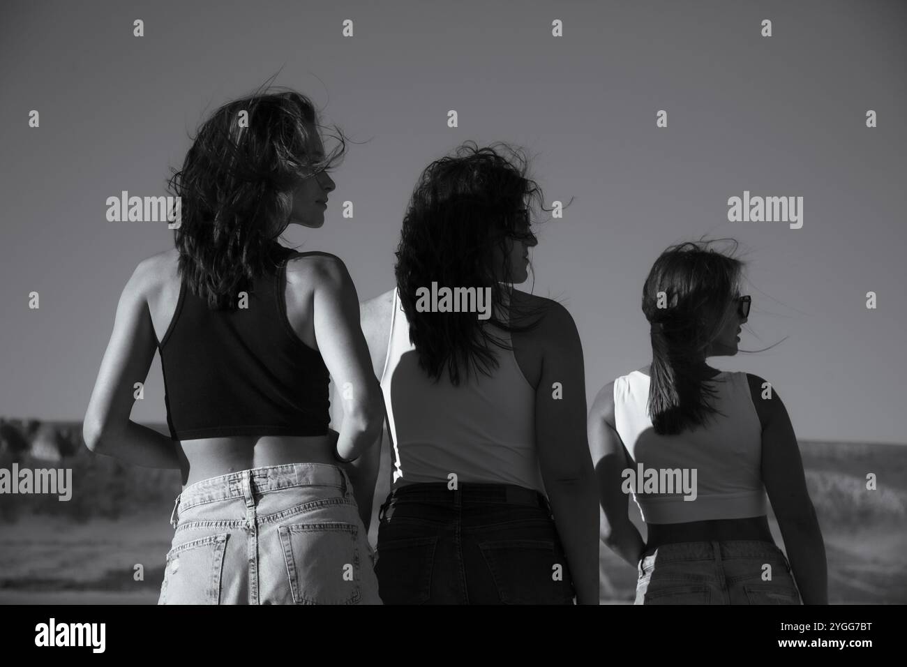Black and white photo. Three young attractive women stand with their ...