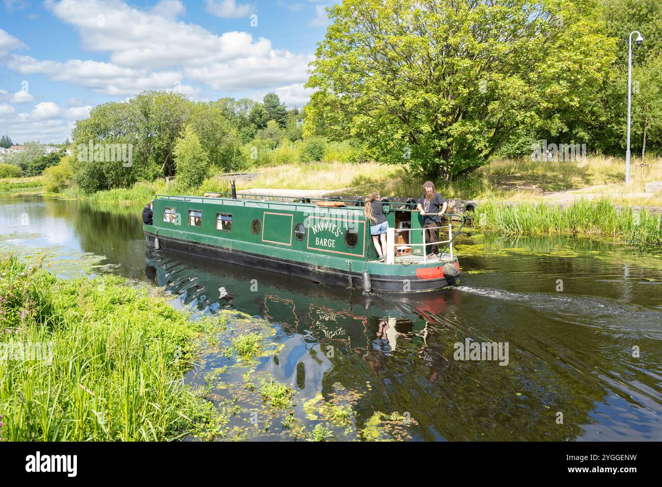 Green canal boat passing through Claypits Nature Reserve on the Forth ...
