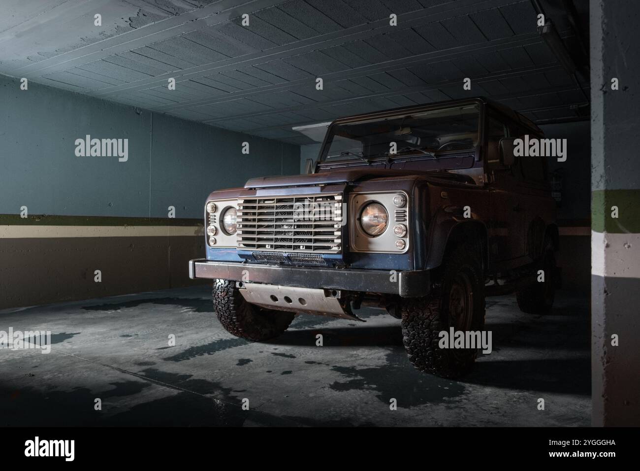 A classic 4x4 mountain car is parked inside a garage. It is hidden by ...