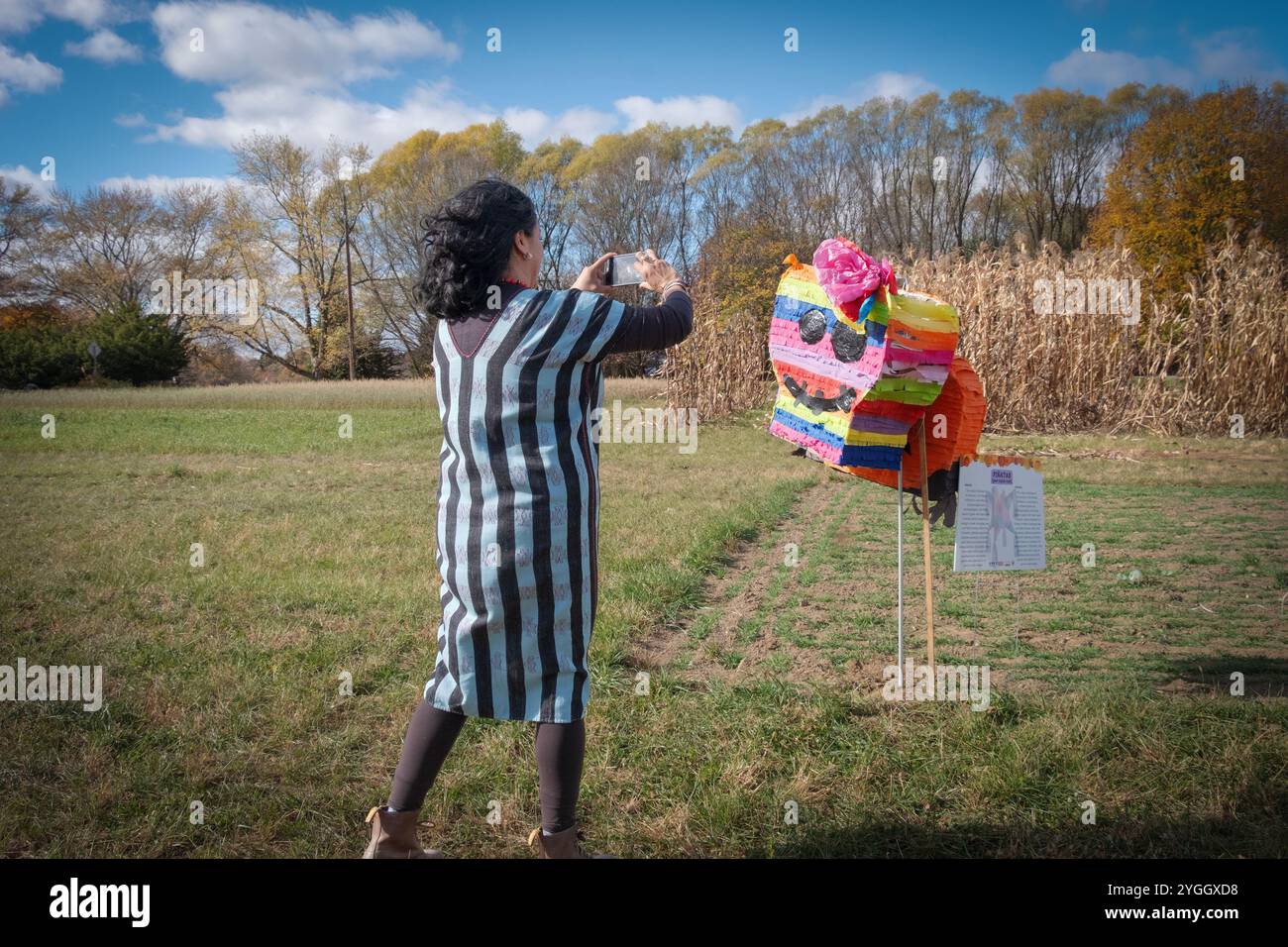 A Mexican American woman takes a photo of a pinata she designed for the ...