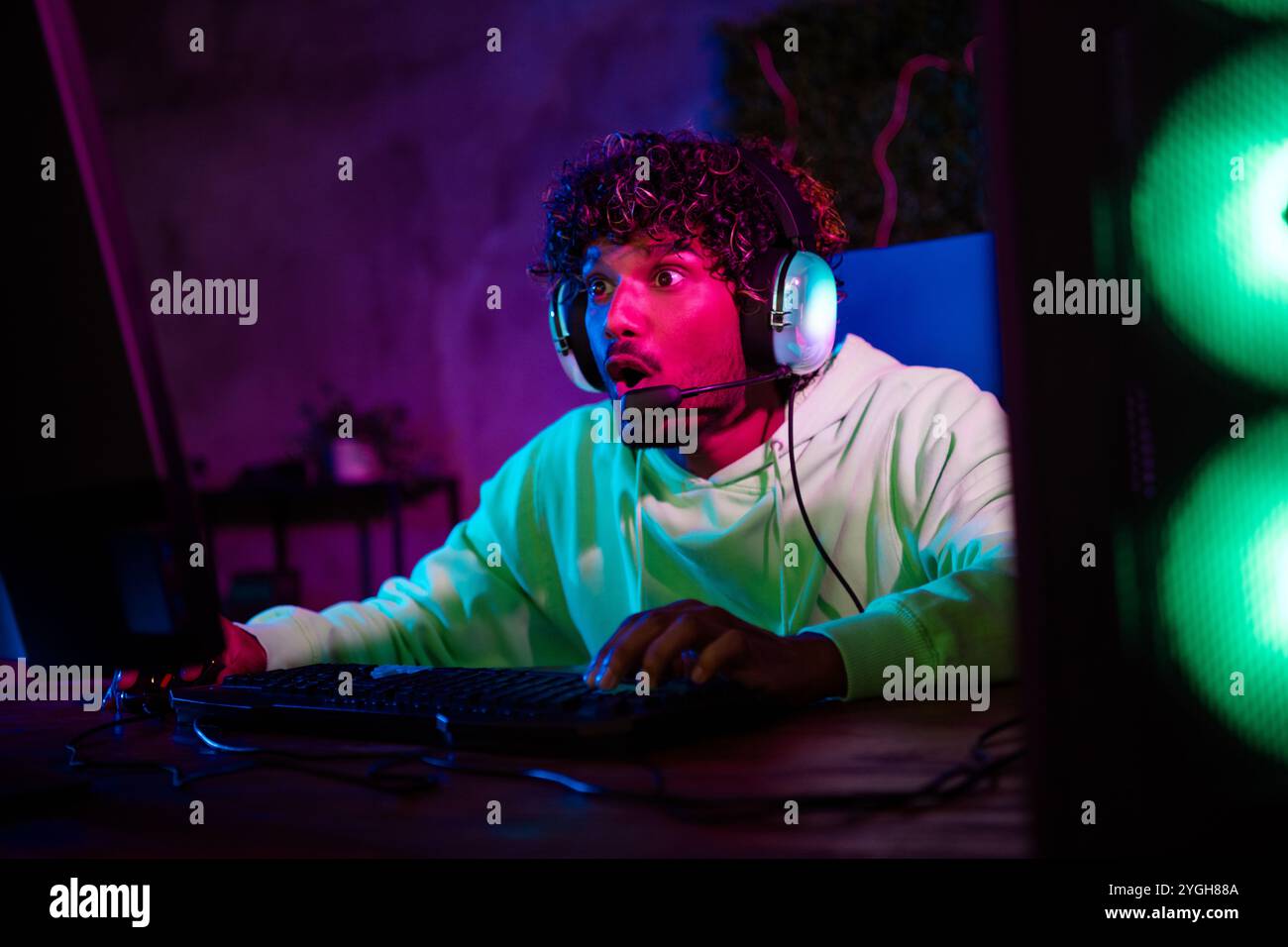 Photo of cute young guy amazed surprised play gamer computer purple ...