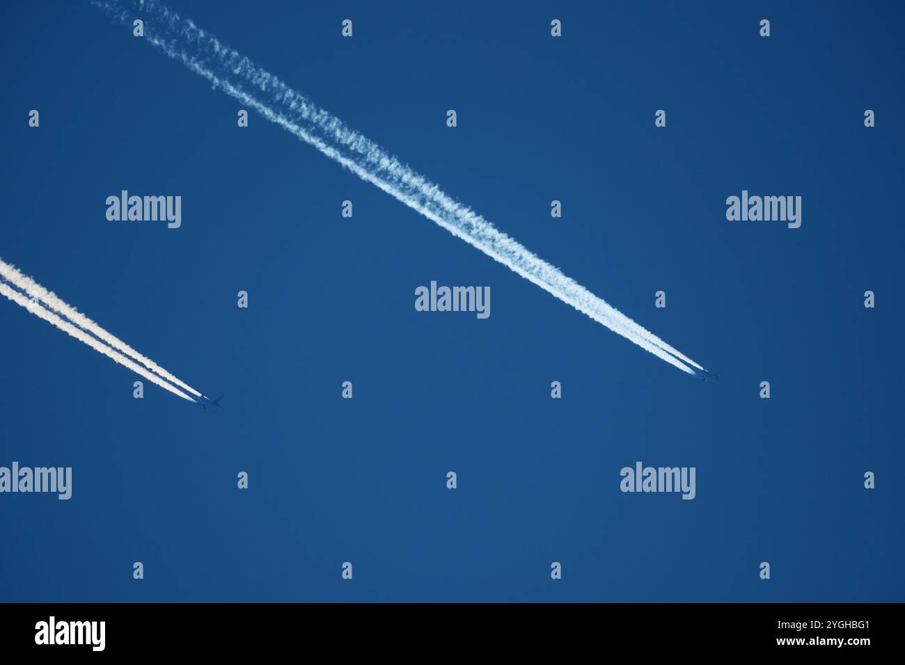 Airplane trails in the blue sky, contrails Stock Photo - Alamy