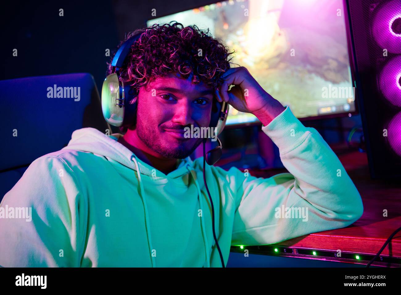 Photo of cute young guy play gamer computer purple blue neon light ...