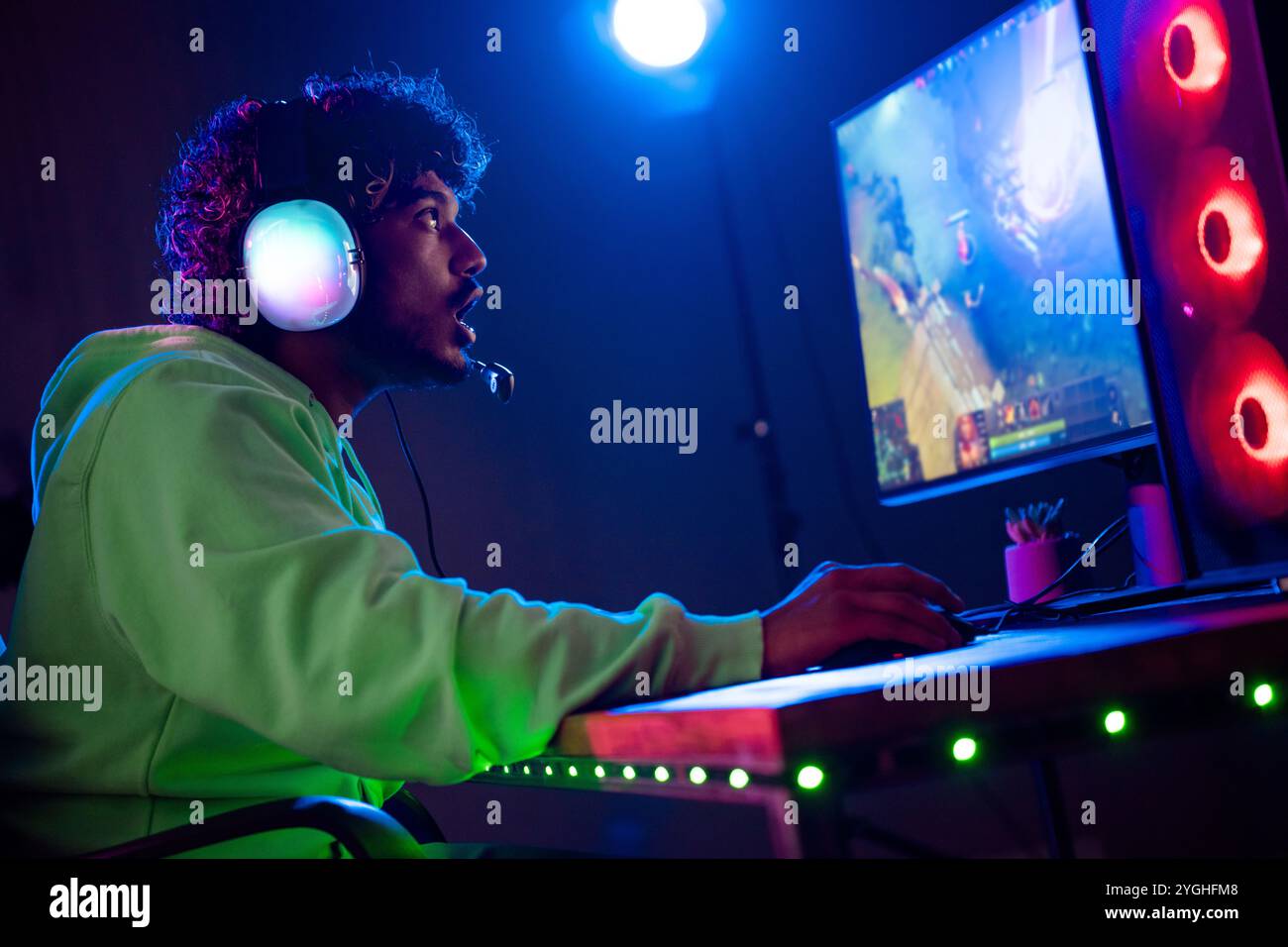 Photo of handsome young man excited amazed sit table play gamer ...