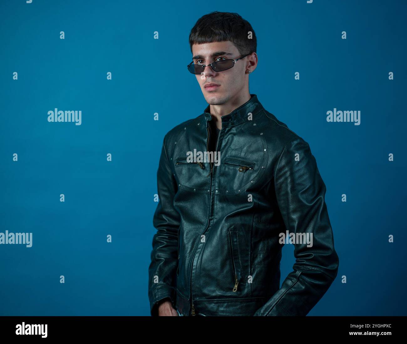 Stylish young man with sunglasses and leather jacket posing confidently ...