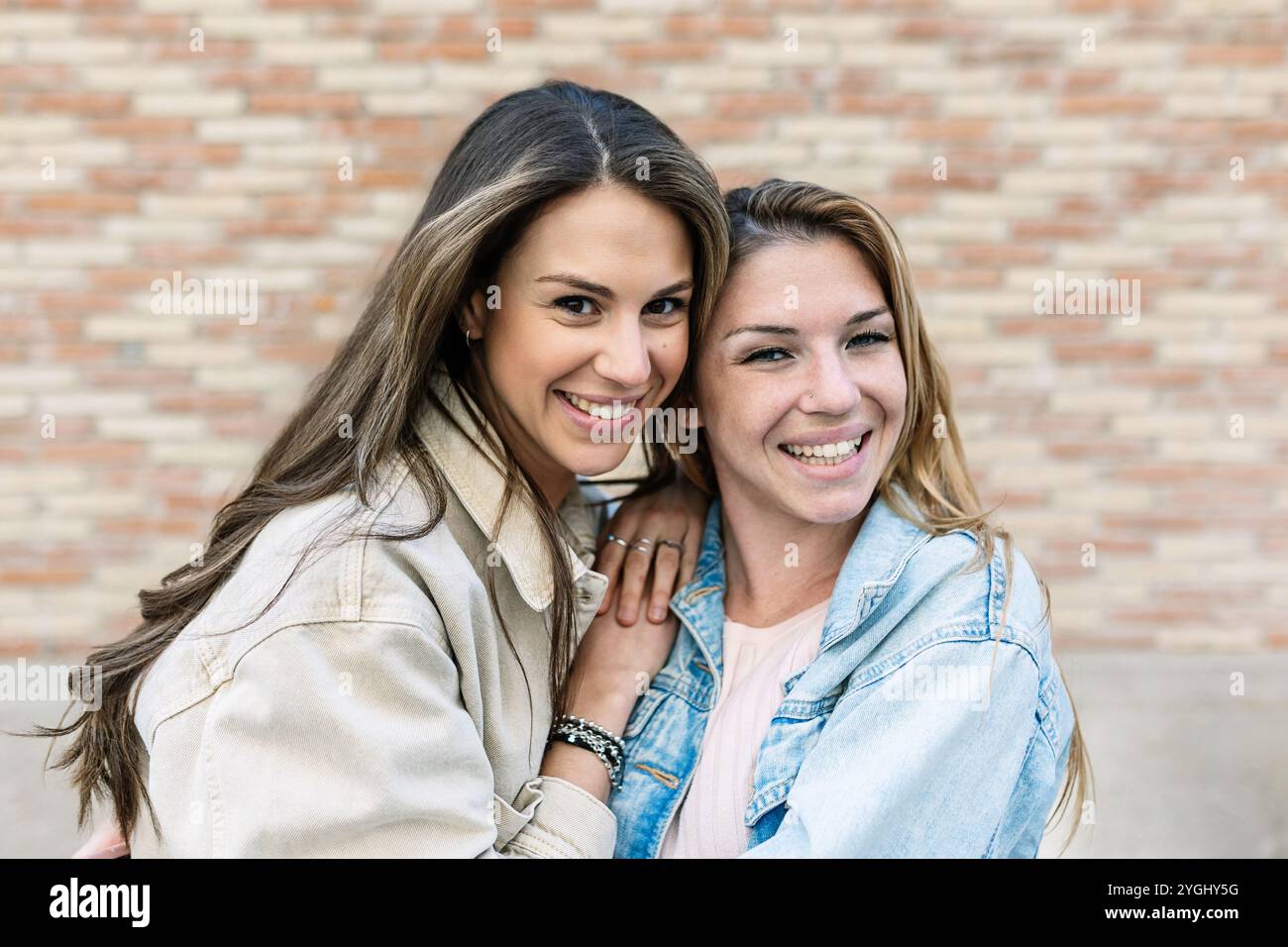 Portrait of two happy women friends hugging each other smiling at ...