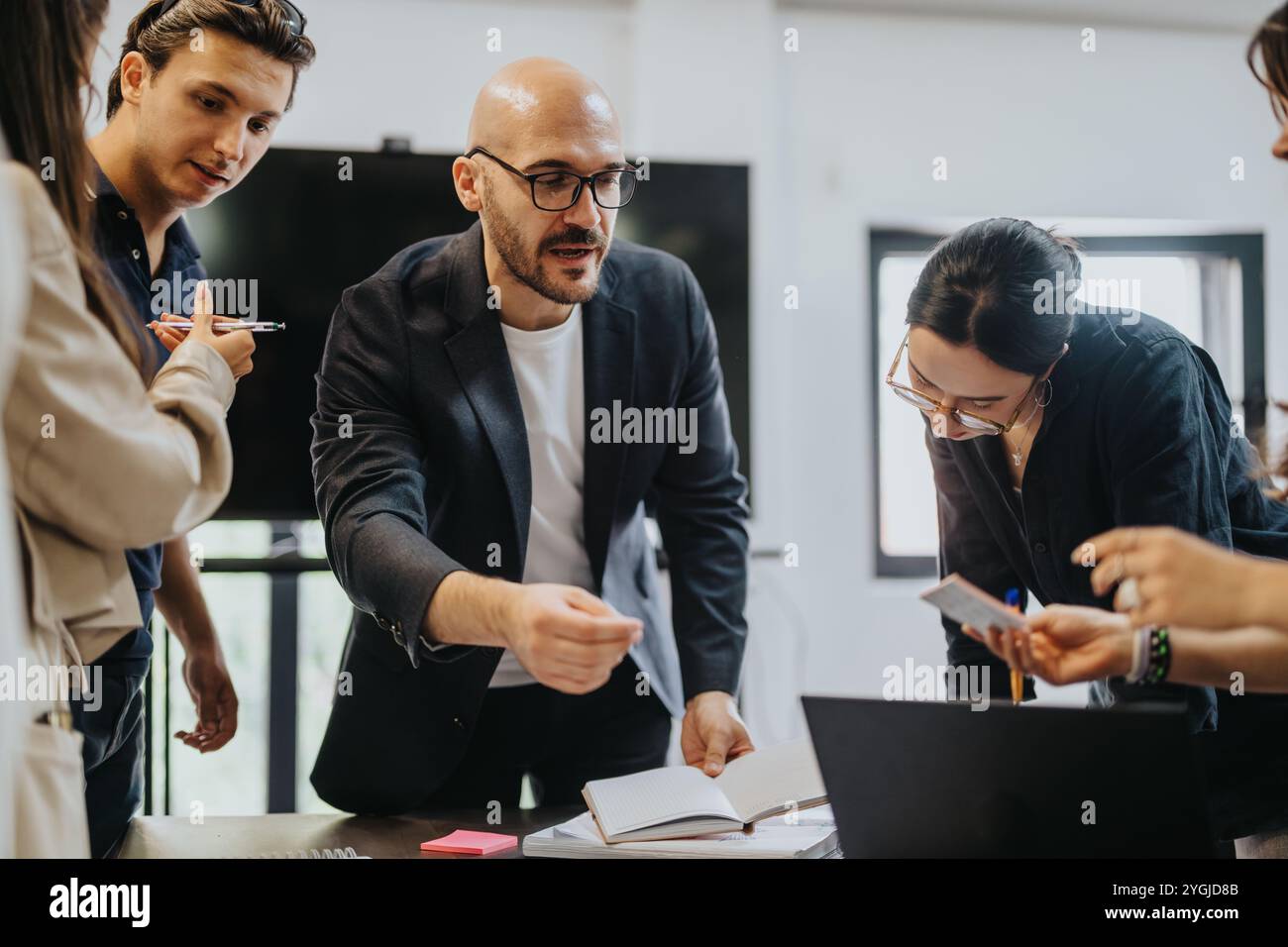 Students collaborating with professor on academic project for guidance ...
