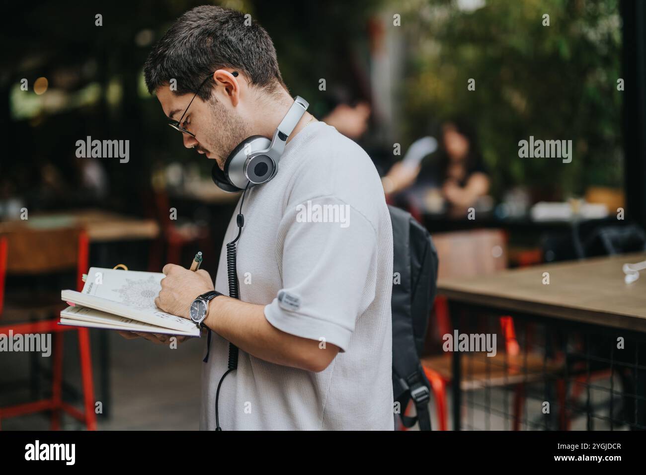 Focused high school student studying in a modern outdoor cafe Stock ...