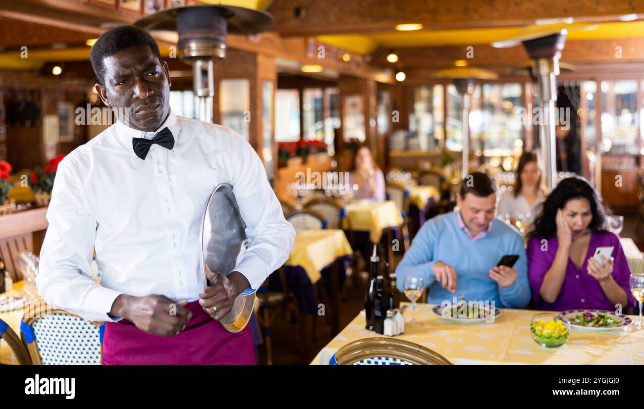 Portrait of sad waiter in restaurant Stock Photo - Alamy