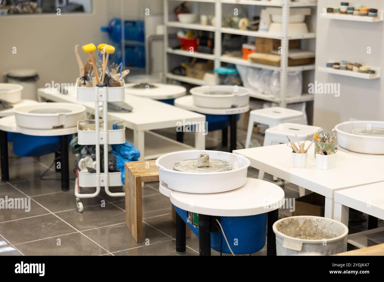 Pottery wheels and tables in ceramics workshop Stock Photo - Alamy
