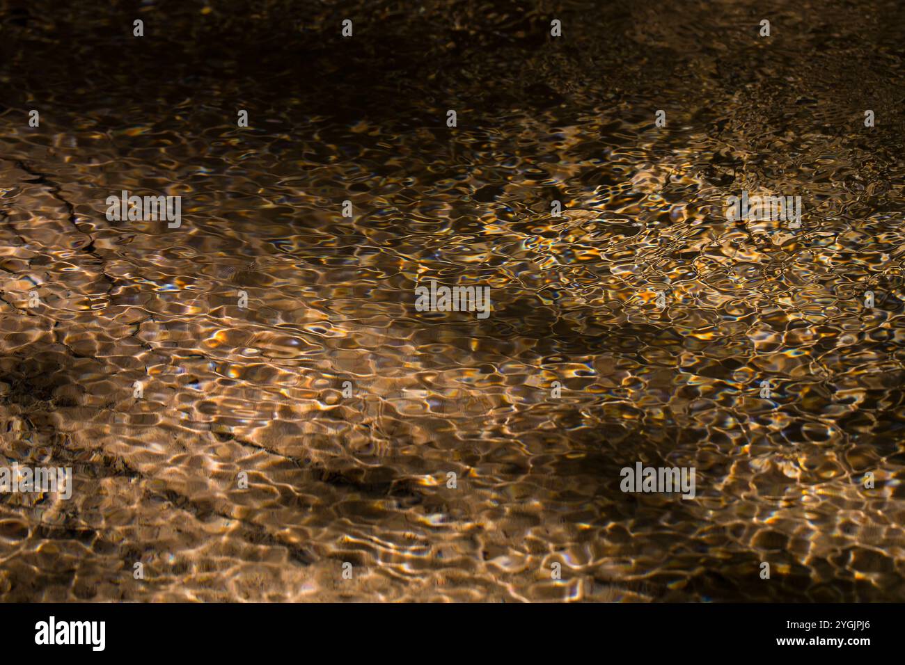 Light reflections caused by sunlight on the surface of a stream, small waves, Germany Stock ...