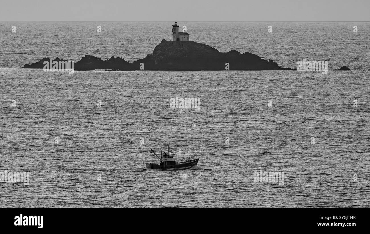 Fishing boat in front of lighthouse Stock Photo - Alamy