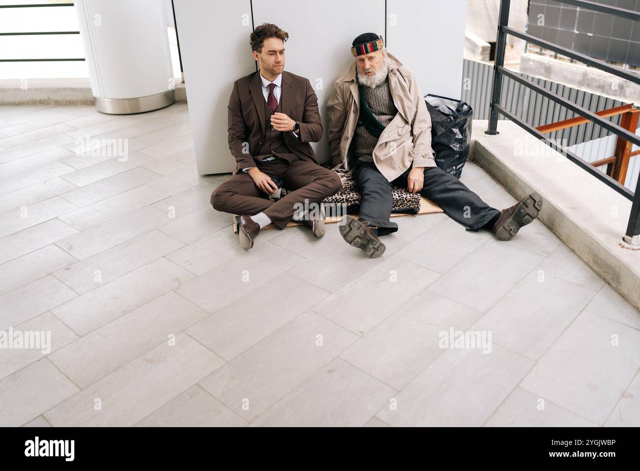 Contrasting image of chatting young businessman in suit with elderly ...