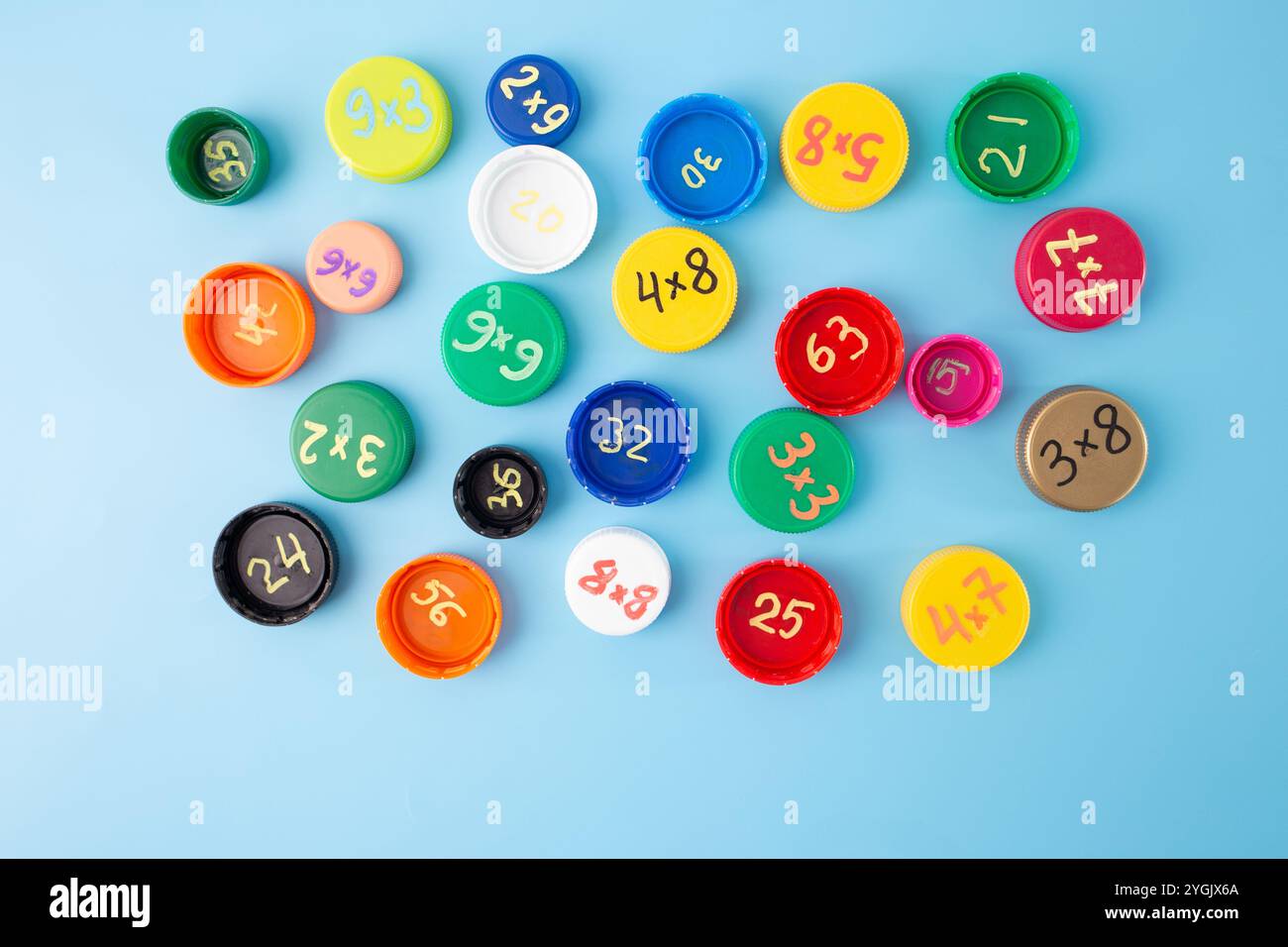 Colorful bottle caps with multiplication problems on blue background ...