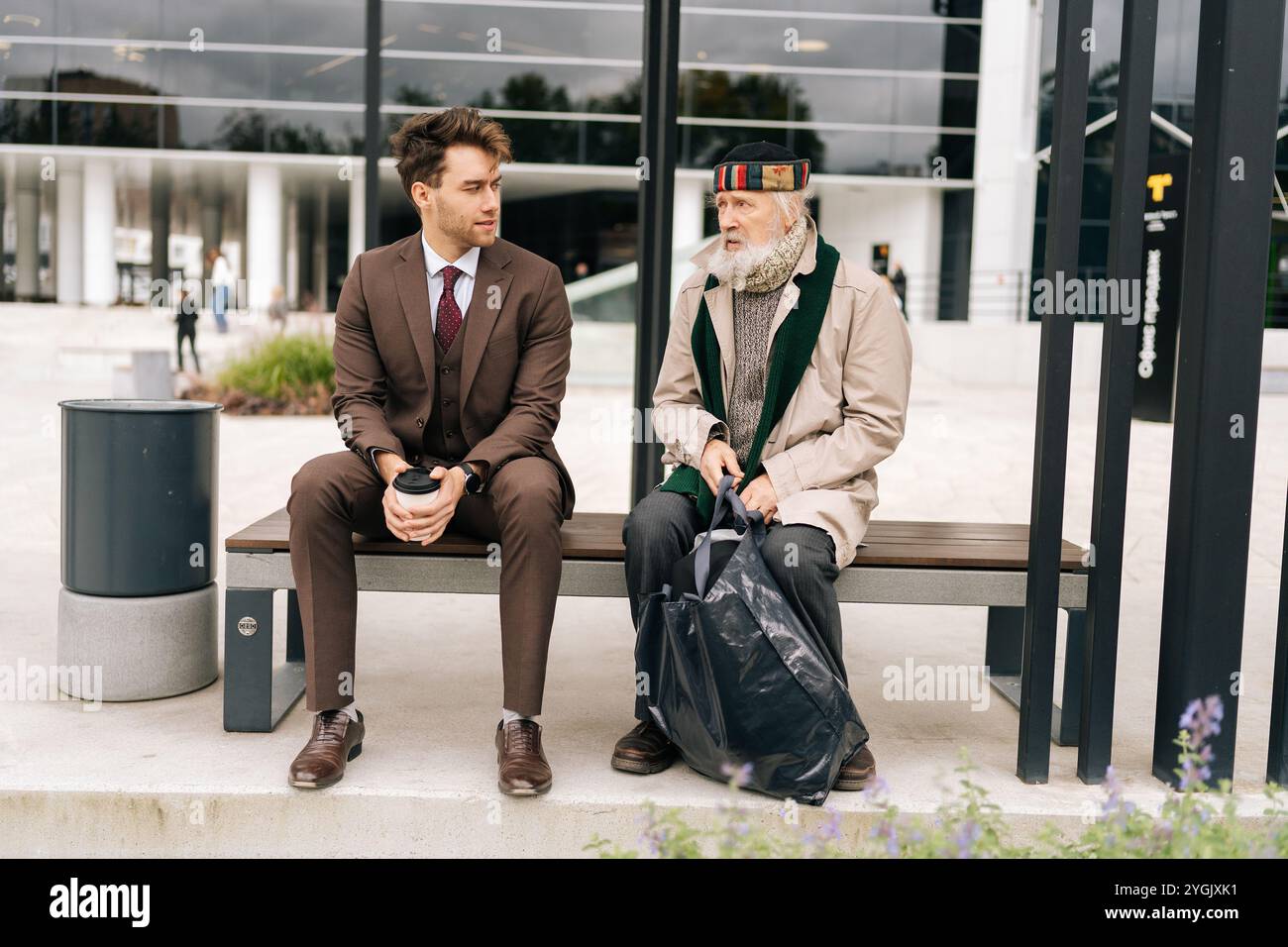 Caring successful businessman in suit holding coffee cup, talking and ...