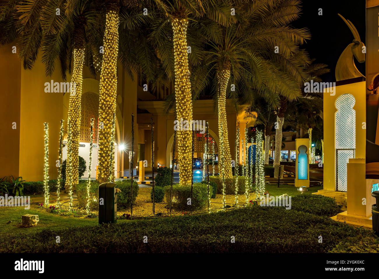 Illuminated palm trees, building entrance near Pearl Island, Arcades ...