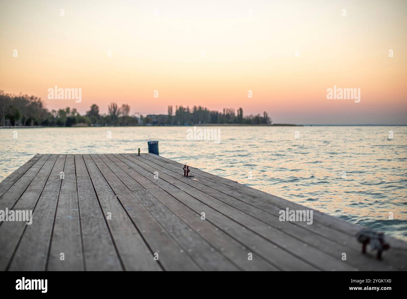Sunrise on the shore and harbor of a lake in summer. Colorful sky with ...
