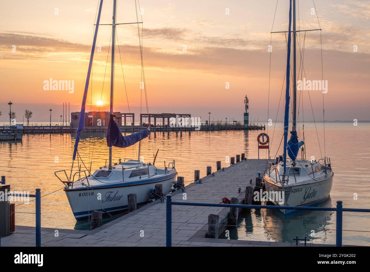Sunrise on the shore and harbor of a lake in summer. Colorful sky with ...