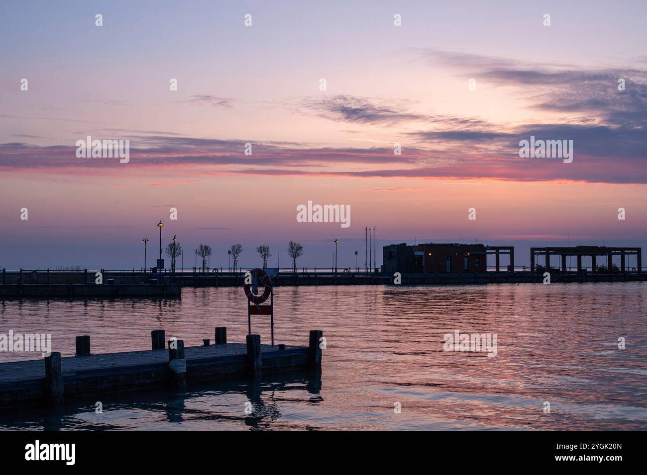 Sunrise on the shore and harbor of a lake in summer. Colorful sky with ...