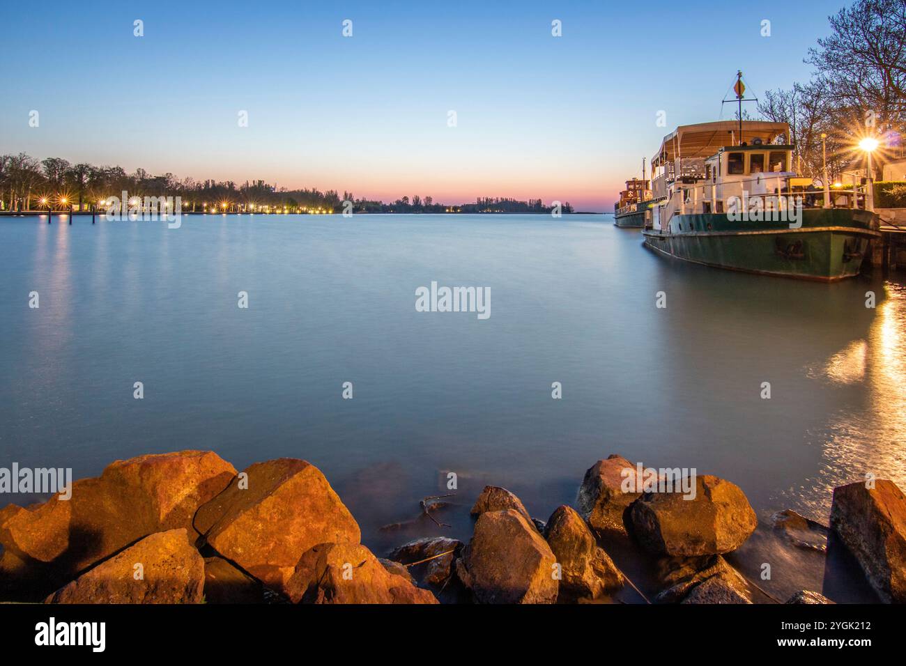 Sunrise on the shore and harbor of a lake in summer. Colorful sky with ...