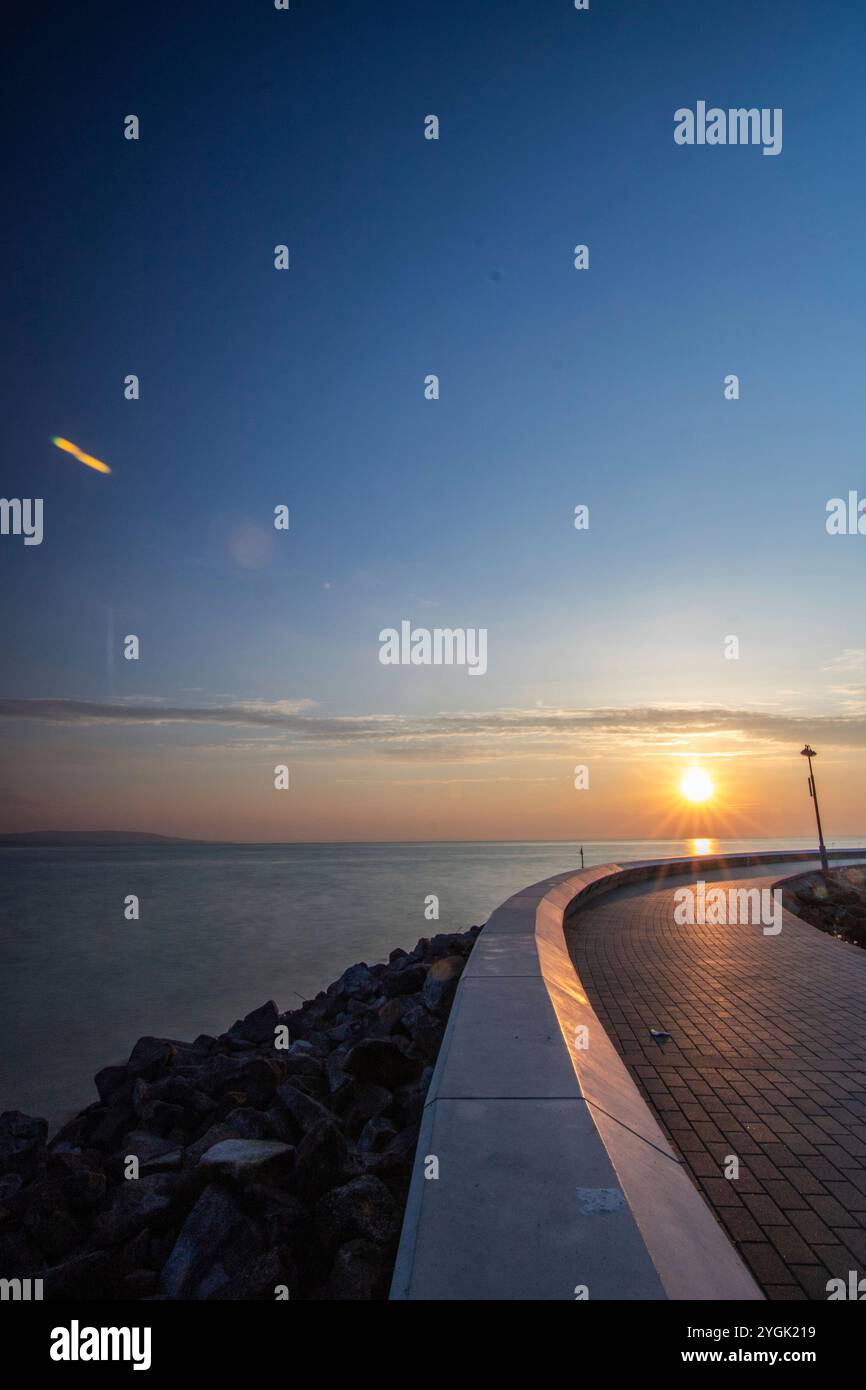 Sunrise on the shore and harbor of a lake in summer. Colorful sky with ...