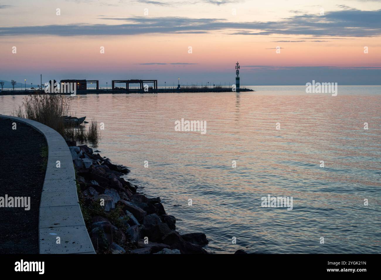 Sunrise on the shore and harbor of a lake in summer. Colorful sky with ...