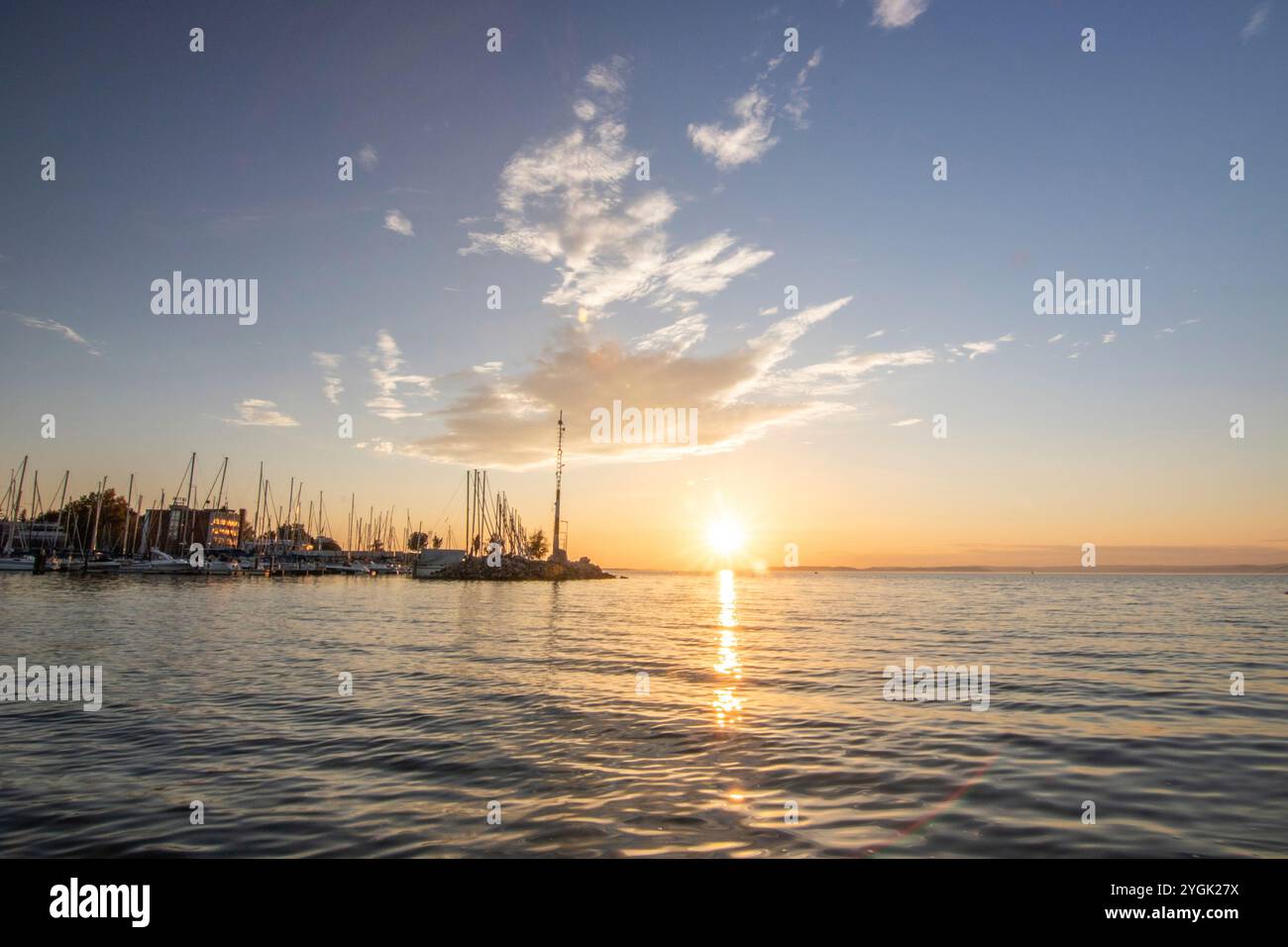 Fantastic sunset on a large lake. Standing on the shore and looking ...