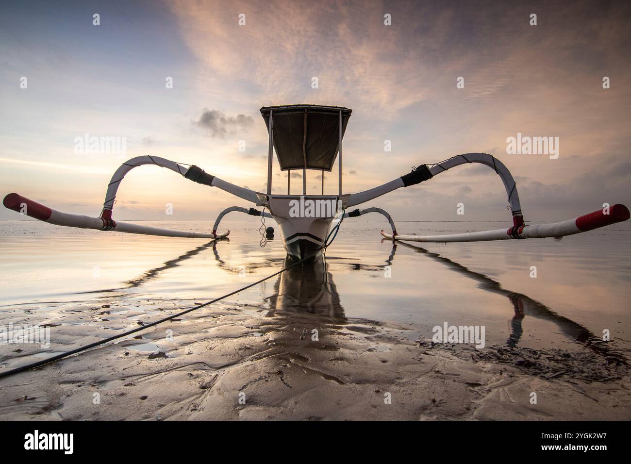 Fantastic sunrise on the beach with small temples and a traditional ...