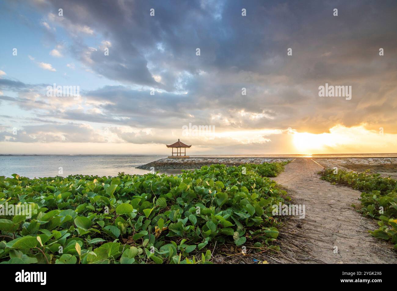 Fantastic sunrise on the beach with small temples and built as ...