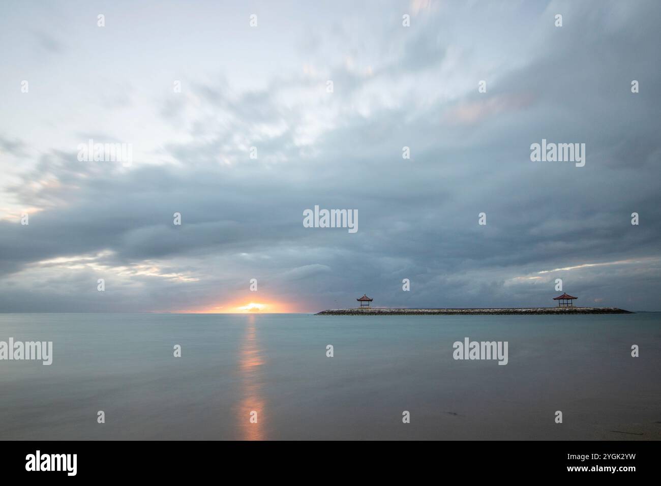 Fantastic sunrise on the beach with small temples. View of the sea as ...