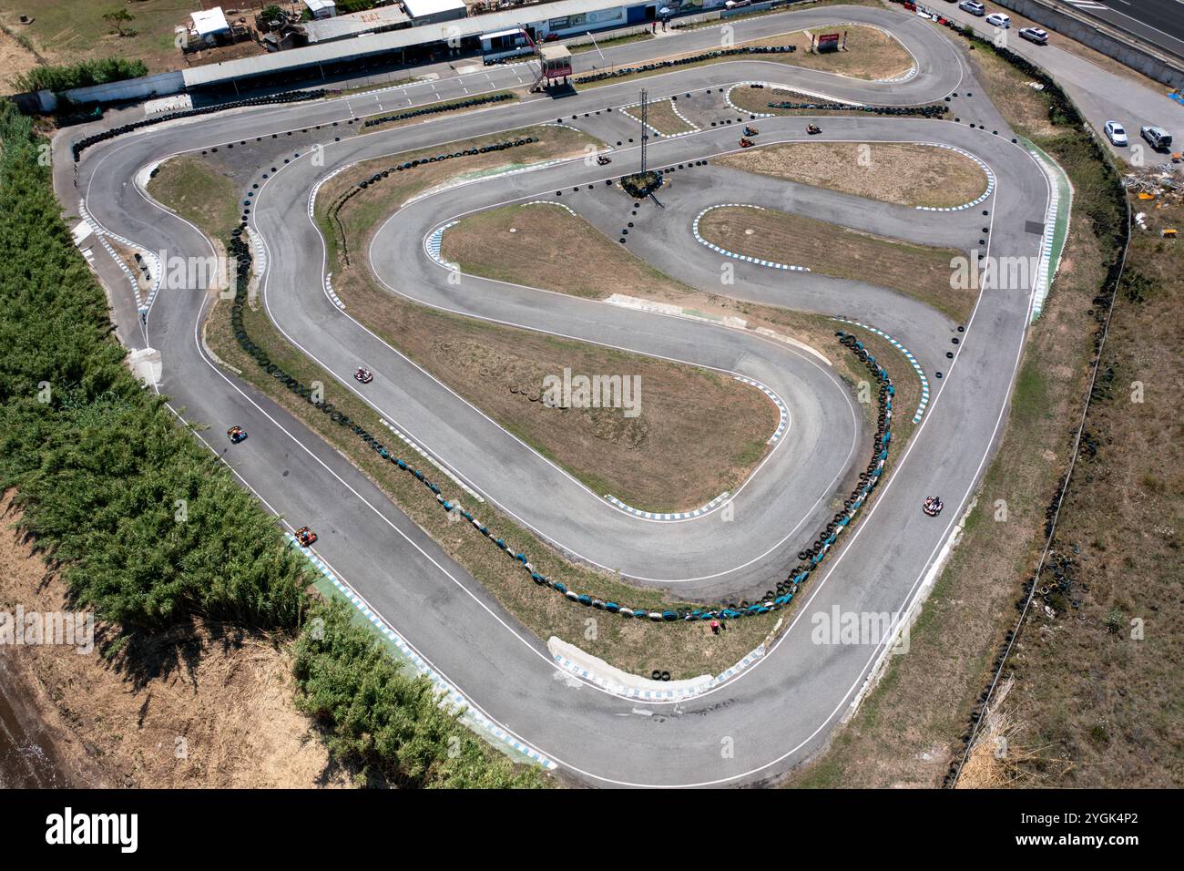 Drone capturing go-karts moving on winding race tracks from top aerial ...