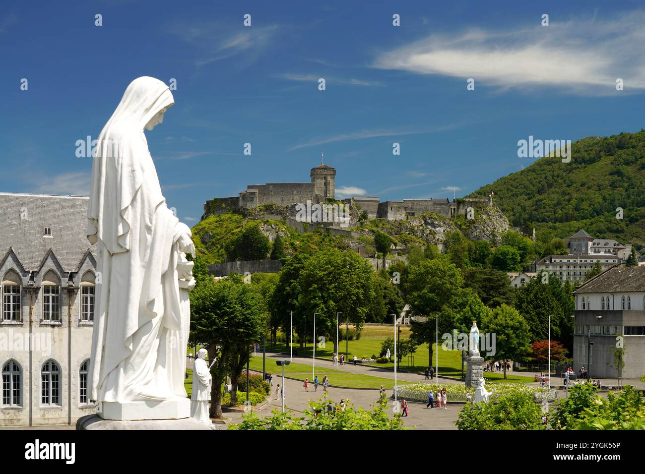 Statue on Rosary Square and the Château fort de Lourdes fortress in the ...