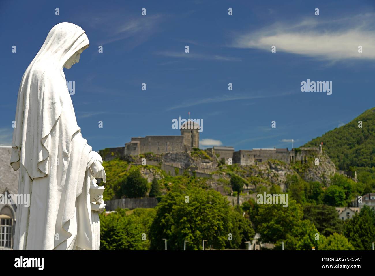 Statue on Rosary Square and the Château fort de Lourdes fortress in the ...