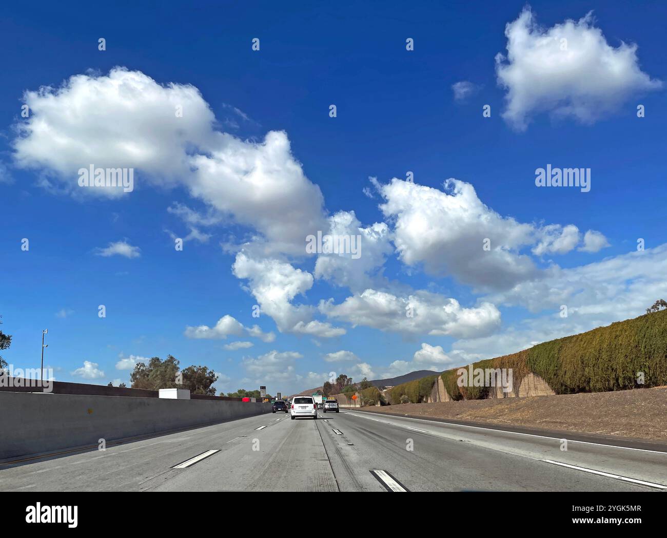 View through windshield of car driving on freeway with white puffy ...
