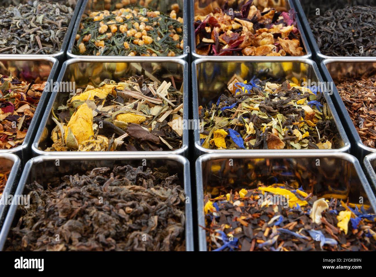 A vibrant assortment of loose-leaf teas in metal tins, featuring green ...