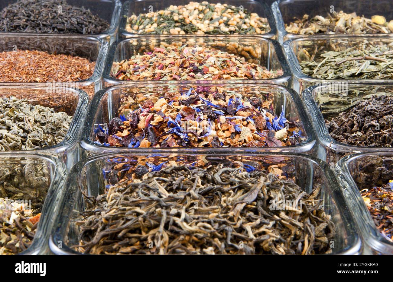 A vibrant assortment of loose-leaf teas in glass jars, featuring green ...