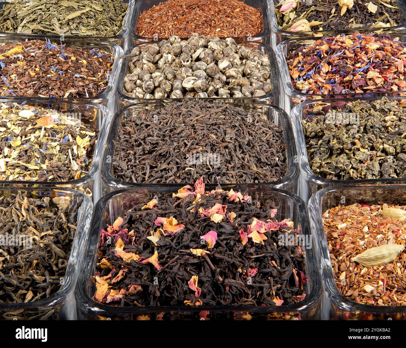 A vibrant assortment of loose-leaf teas in glass jars, featuring green ...