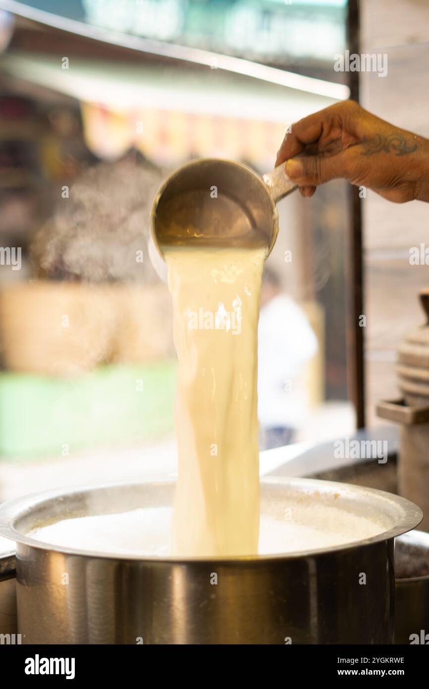 Man pouring boiling milk Stock Photo - Alamy