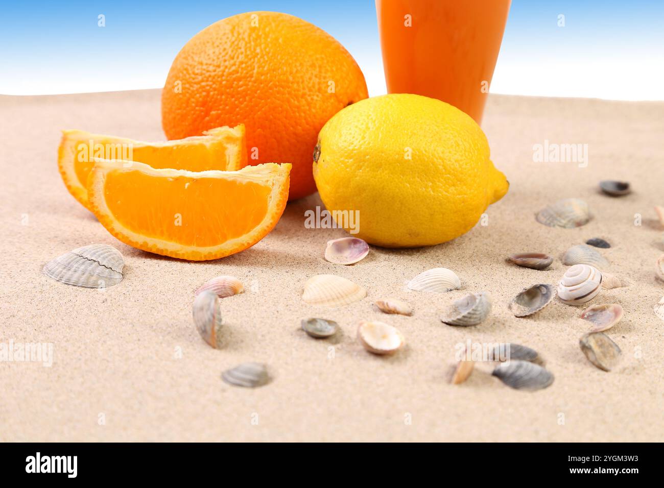 Juice, orange, lime, shells on sand. Blue background Stock Photo - Alamy