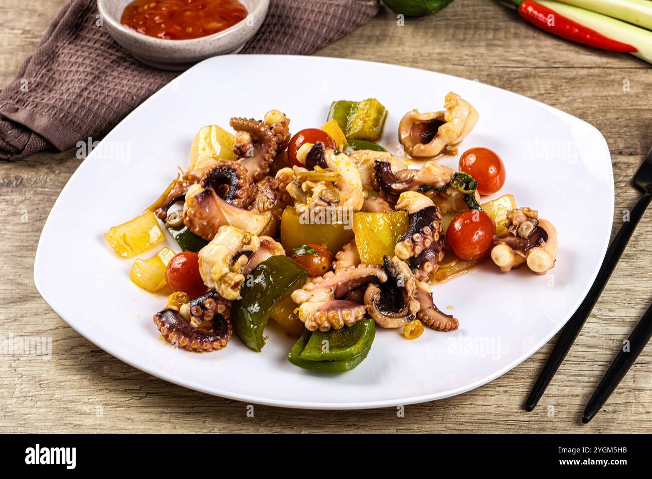 Roasted octopus with vegetables, spices and oil Stock Photo - Alamy